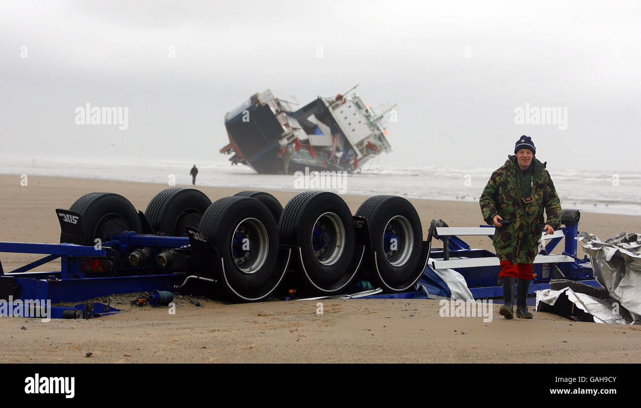 A walks past the wheels of a container lorry that has fallen from the ...