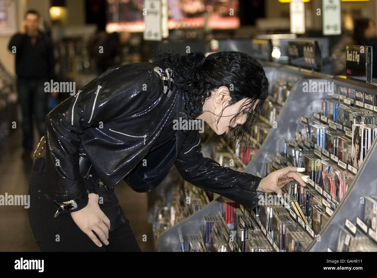 A Michael Jackson look-alike browses the shelves during the launch of the 25th anniversary ...