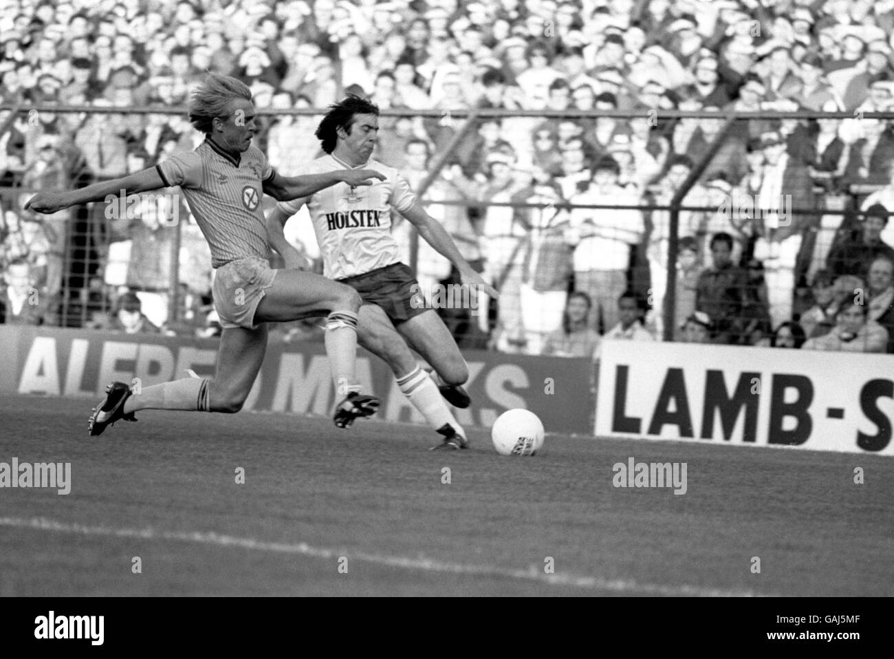 Tottenham Hotspur's Tony Galvin (r) tries to cross the ball as he is ...