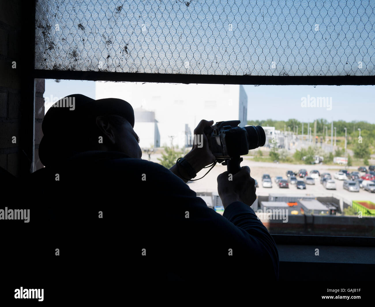 Photographer capturing an image through an abandoned building window ...