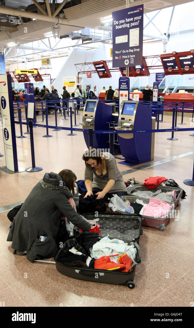 Passengers sort through their luggage as after being delayed by a ...