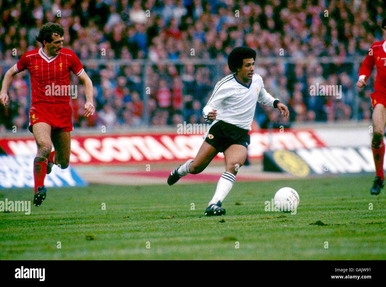 Manchester United's Remi Moses (r) gets past Liverpool's Alan Kennedy ...