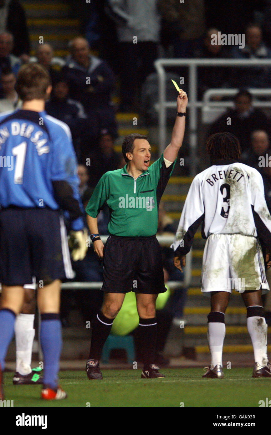 Referee Alan Wiley (l) shows Fulham's Rufus Brevett (r) the yellow card ...