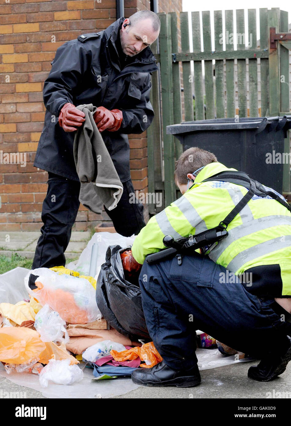 Police officers search through residents' bins in the Dewsbury Moor ...