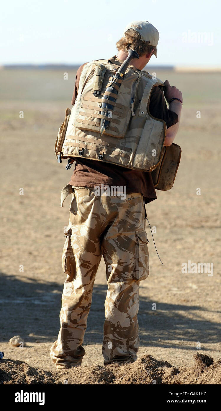 Prince Harry puts on his body armour in the desert in Helmand province ...