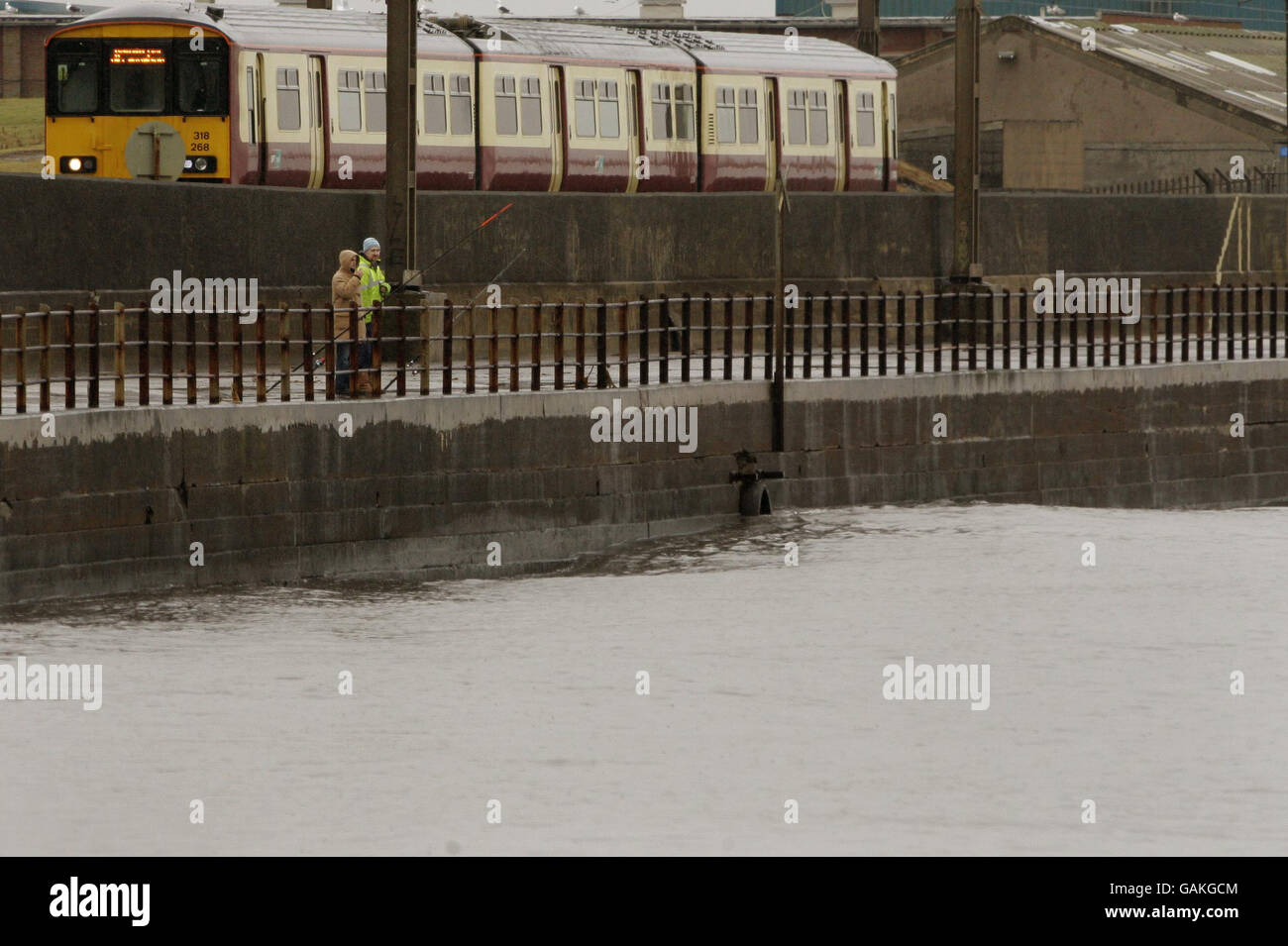 Fishermen on the Saltcoats coast at high tide enjoy the relative calm ...