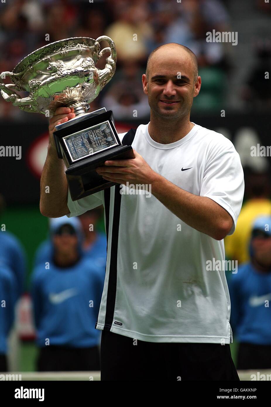 Andre Agassi (USA) holds the trophy after winning the Mens Singles ...