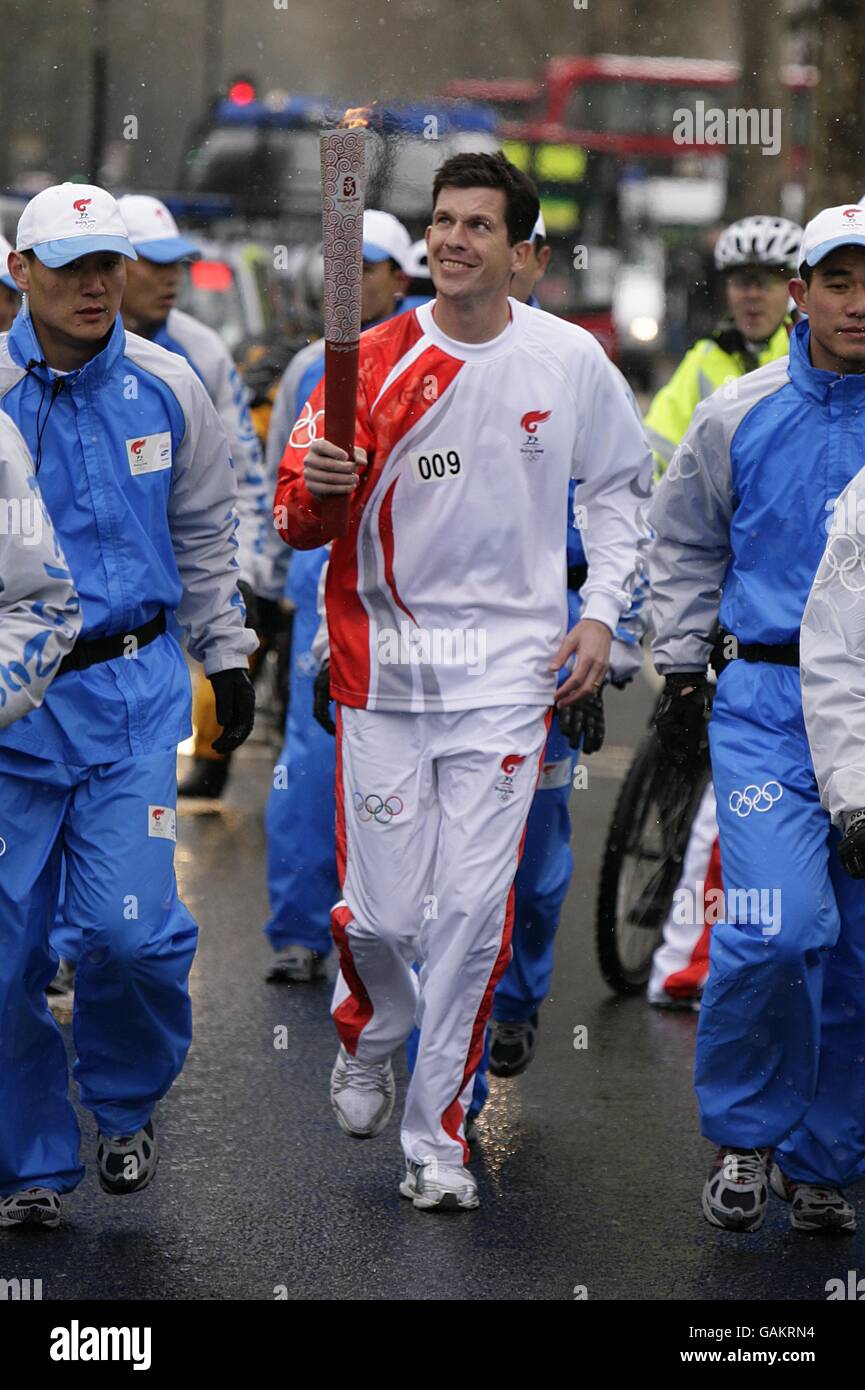 Tim Henman carries the torch as the parade nears Notting Hill Gate ...