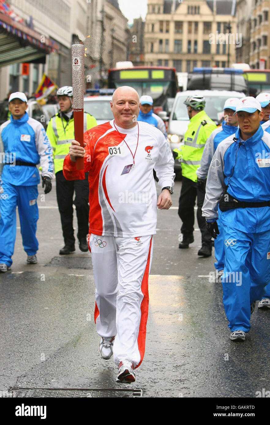 Chelsea football club CEO Peter Kenyon carries the Olympic torch during ...