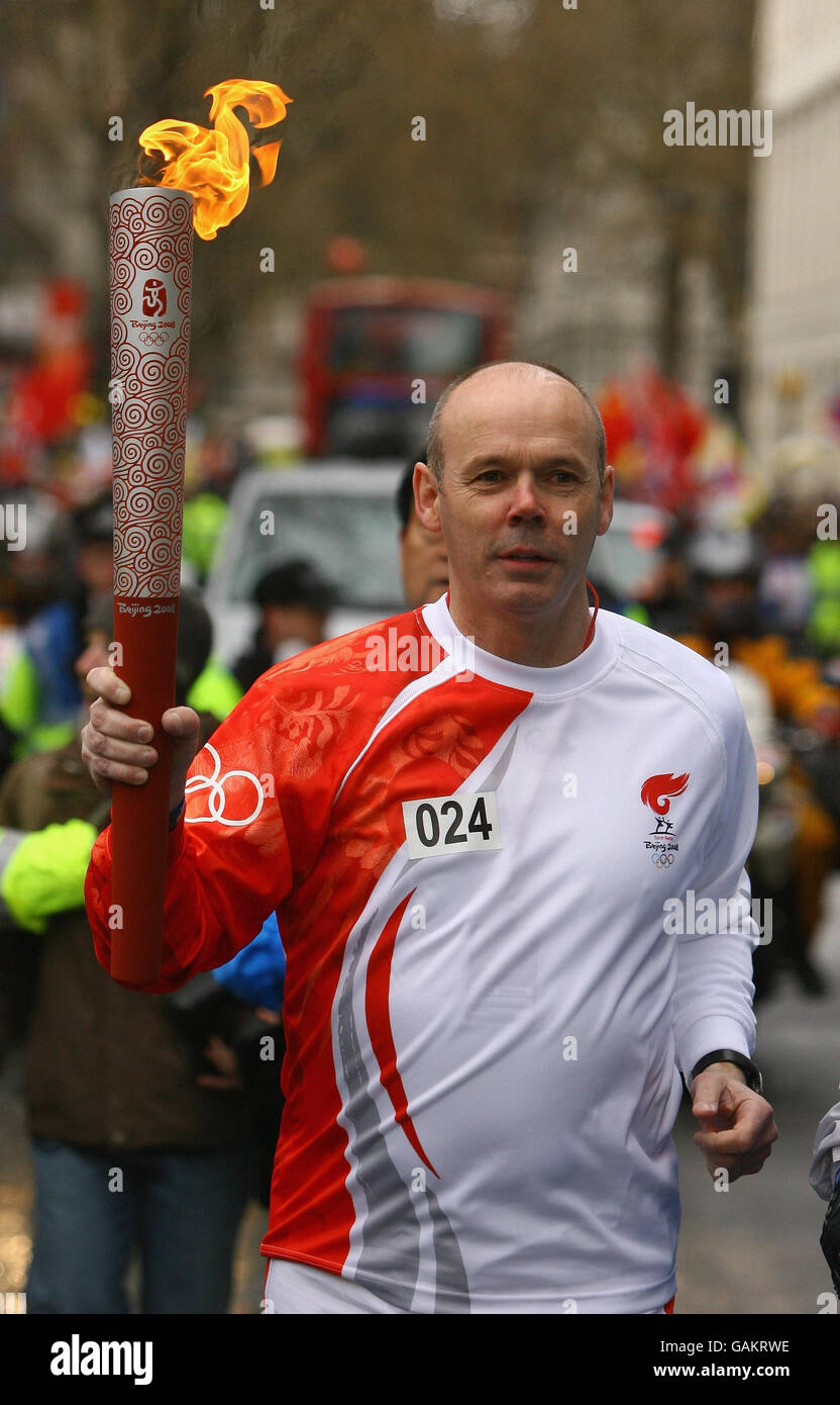 Former England rugby coach Sir Clive Woodward carries the Olympic torch ...