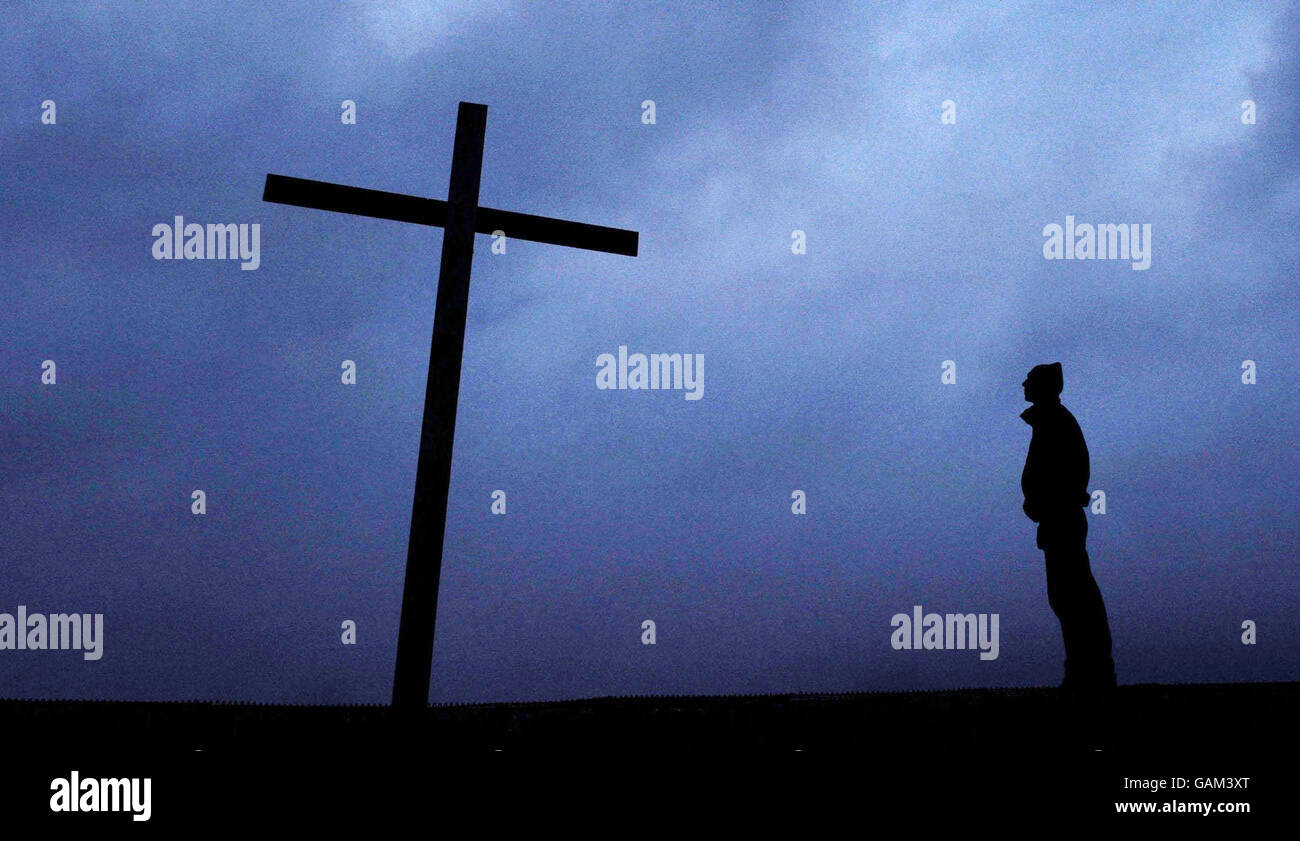 A man stands beside a cross erected to celebrate the Easter holiday as ...