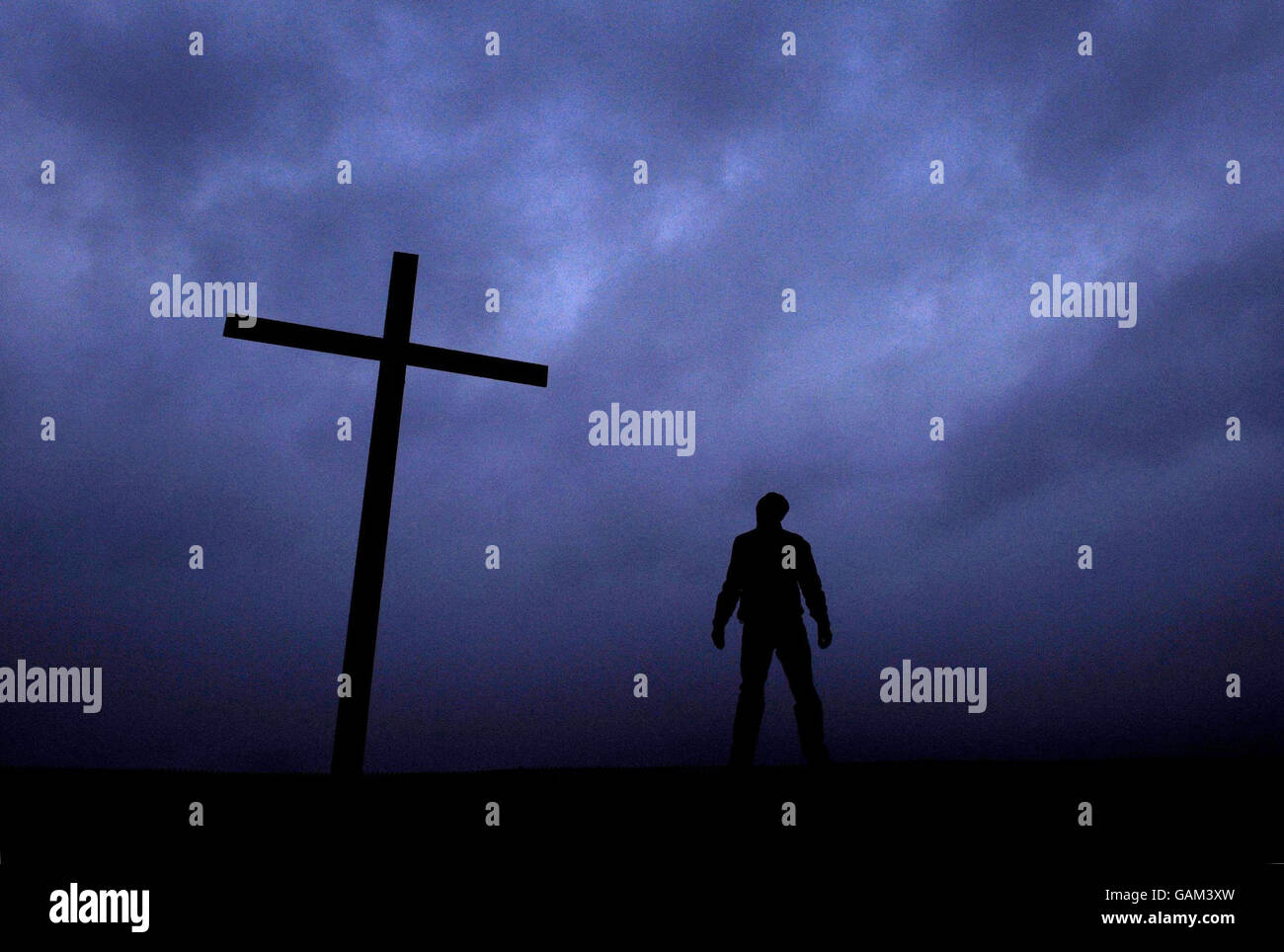 A man stands beside a cross erected to celebrate the Easter holiday as ...