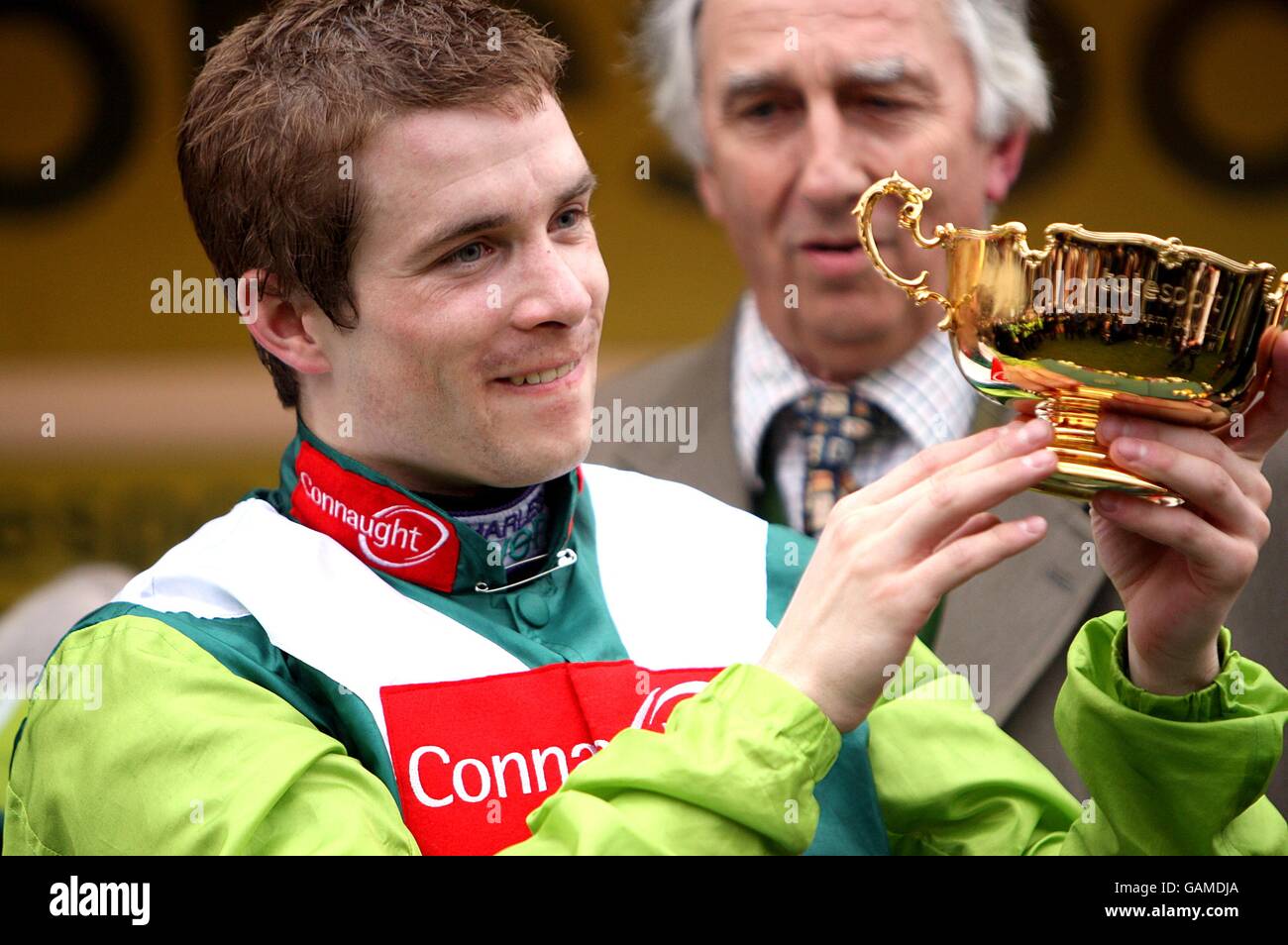 Jockey Sam Thomas celebrates with the trophy after riding to glory on ...