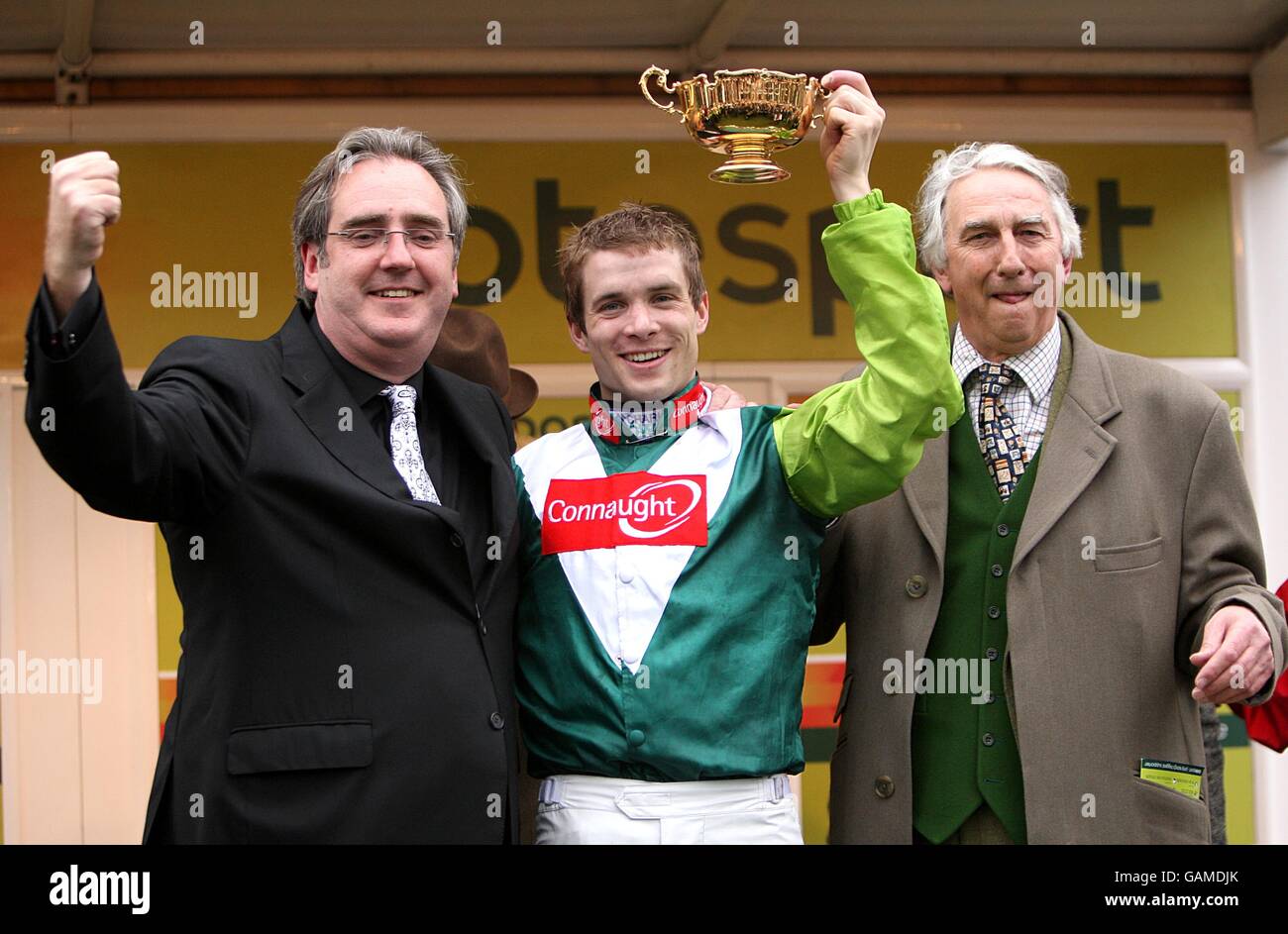 Jockey Sam Thomas celebrates with the trophy alongside owner Mr Paul K ...