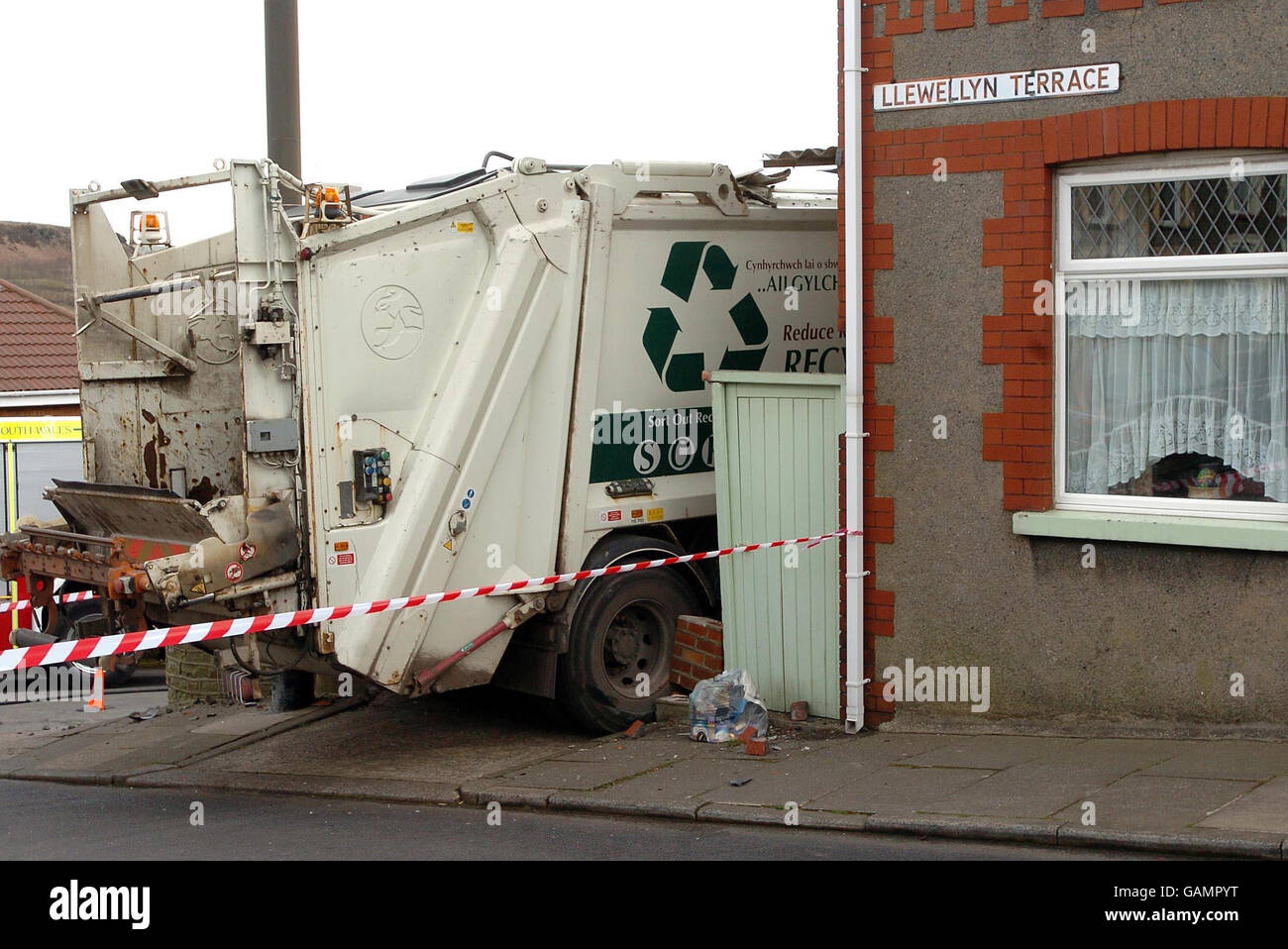 A refuse lorry, after it crashed into parked cars and ends up lodged in ...
