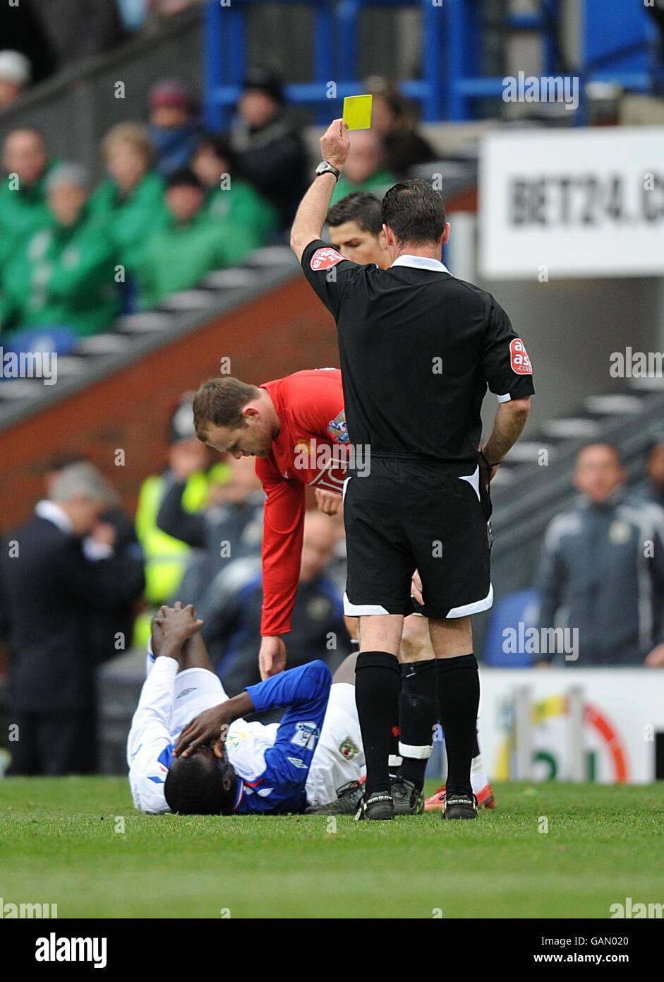 Referee Rob Styles shows the yellow card to Manchester United's Wayne ...