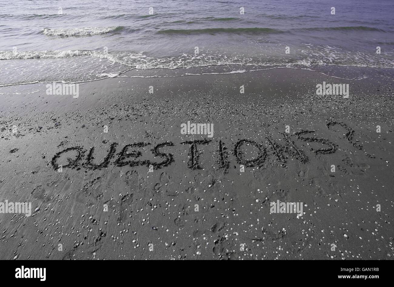 QUESTIONS written in large letters on the sand Stock Photo - Alamy