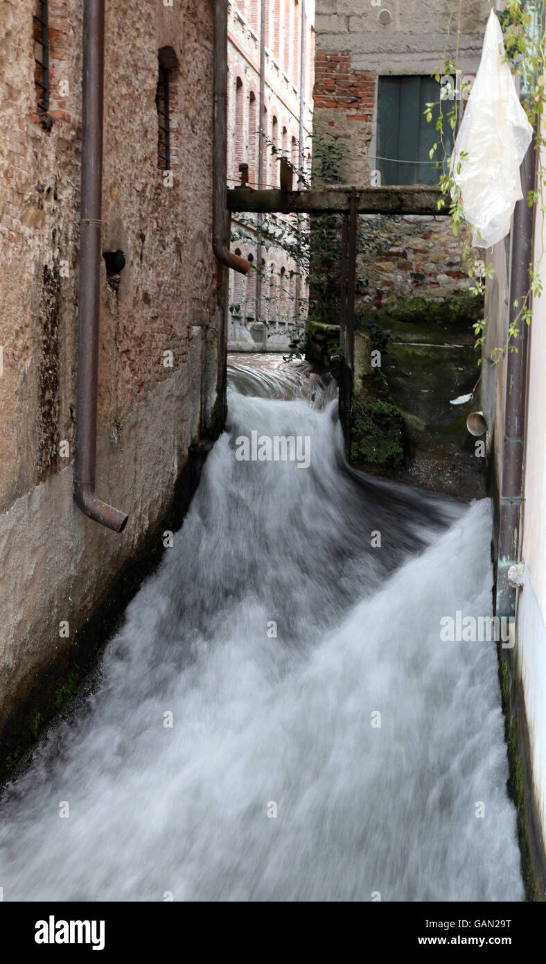 stream with water flowing in the middle of the industrial building ...