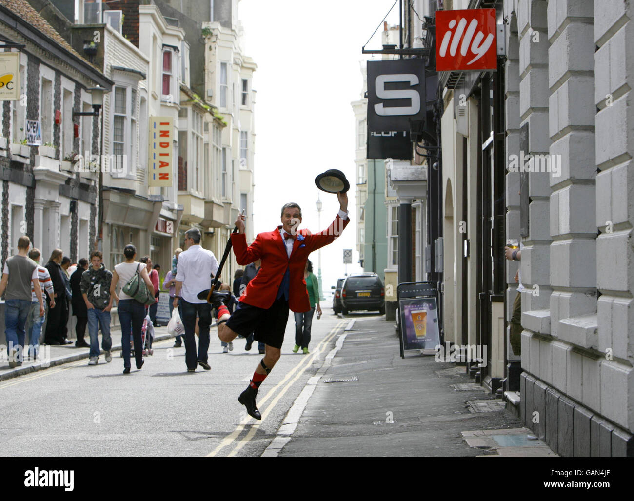 Entertainer Tim Bat practices his act beneath two shop signs in Ship ...