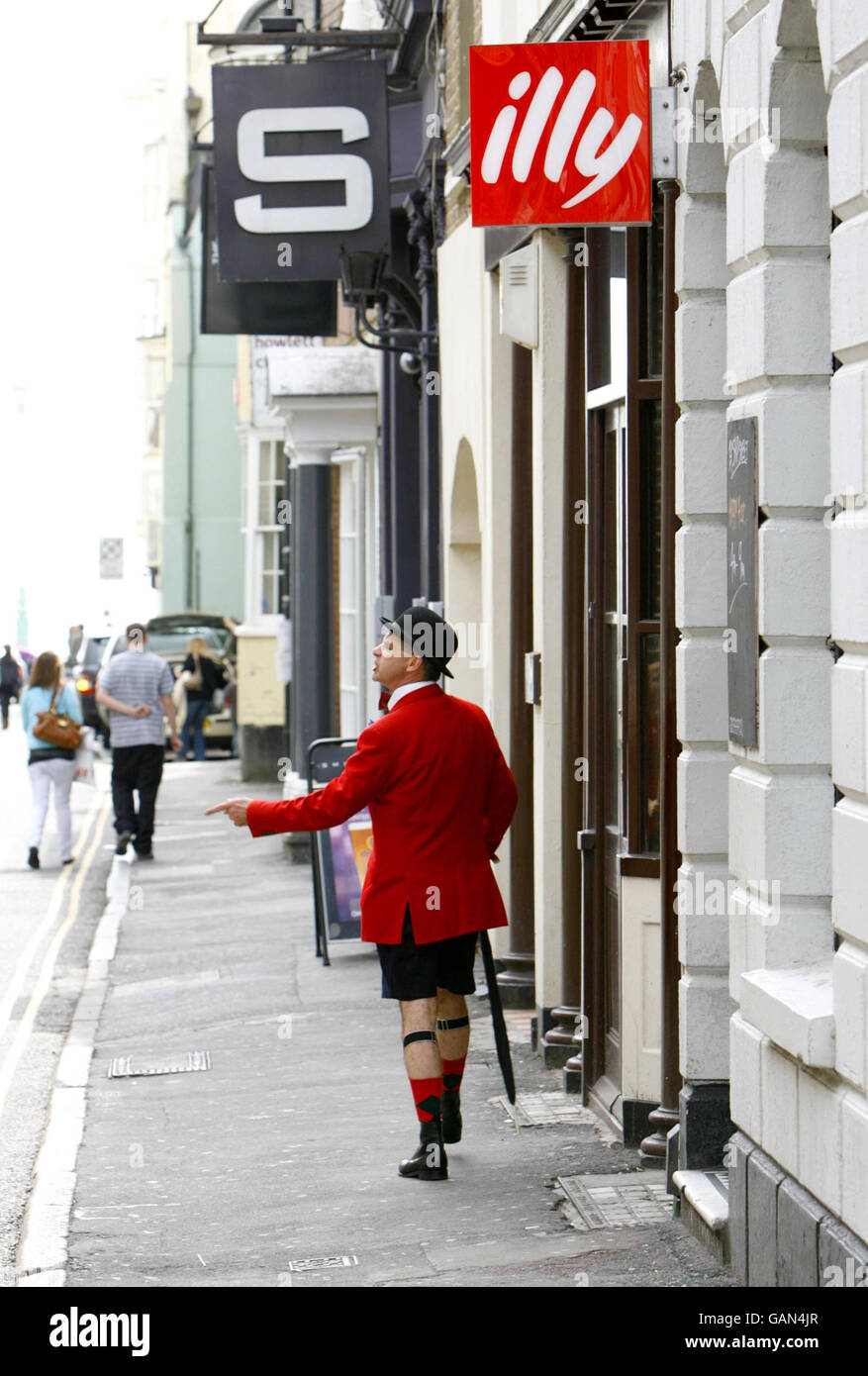 Entertainer Tim Bat practices his act beneath two shop signs in Ship ...