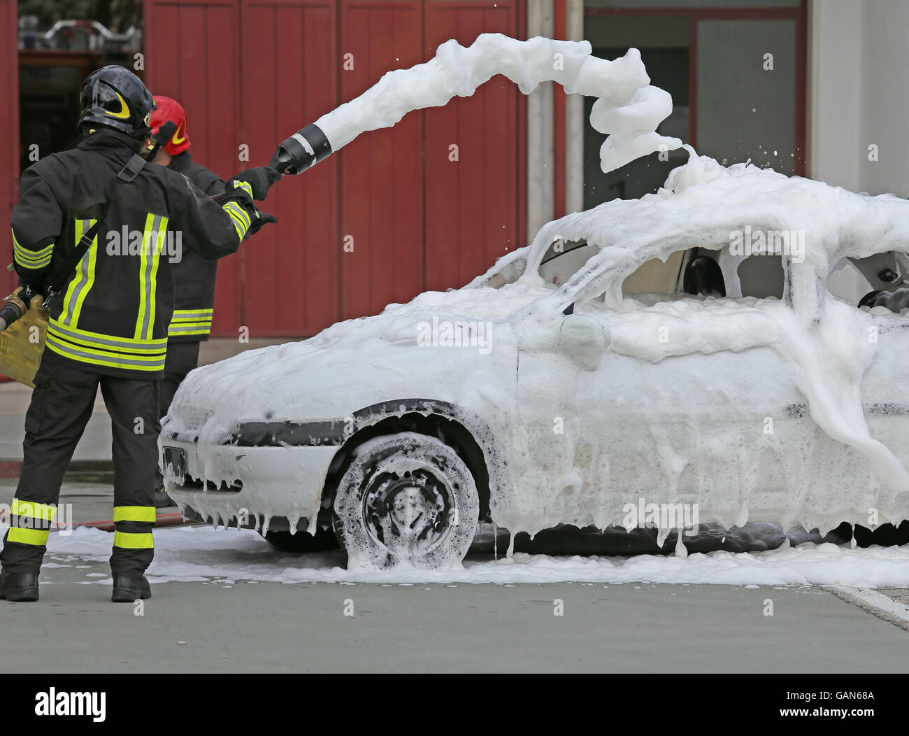 firemen during exercise to extinguish a fire in a car with foam Stock ...