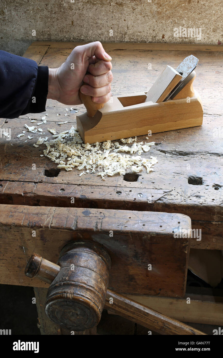 Carpenter's hand in the carpentry workshop with a plane and the ...