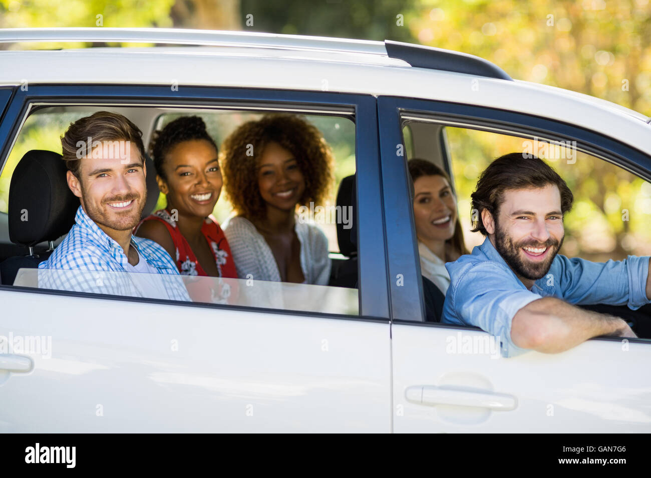 Group of friends looking out from car window Stock Photo - Alamy
