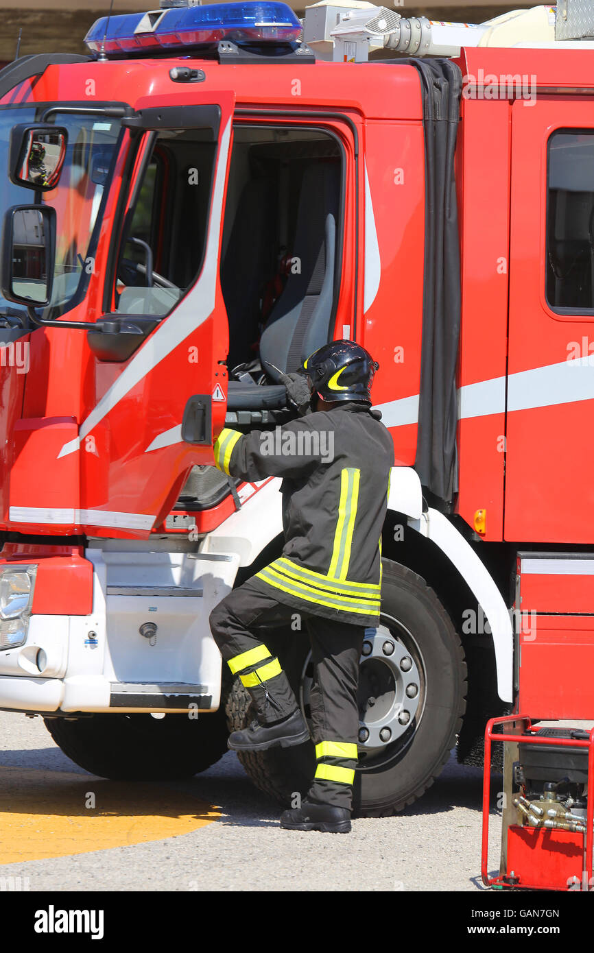 brave firefighters in action jump down quickly from the firetruck ...