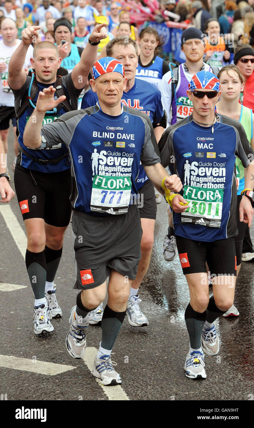 Flora London Marathon. The blind runner Dave Heeley (left) crosses Tower Bridge during the ...