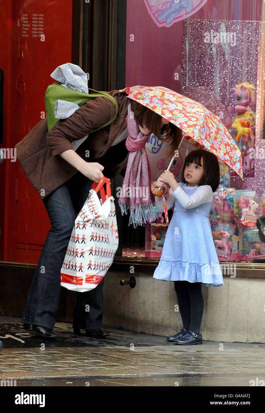 Lucy Gough and her daughter shelter under an umbrella as heavy rain ...