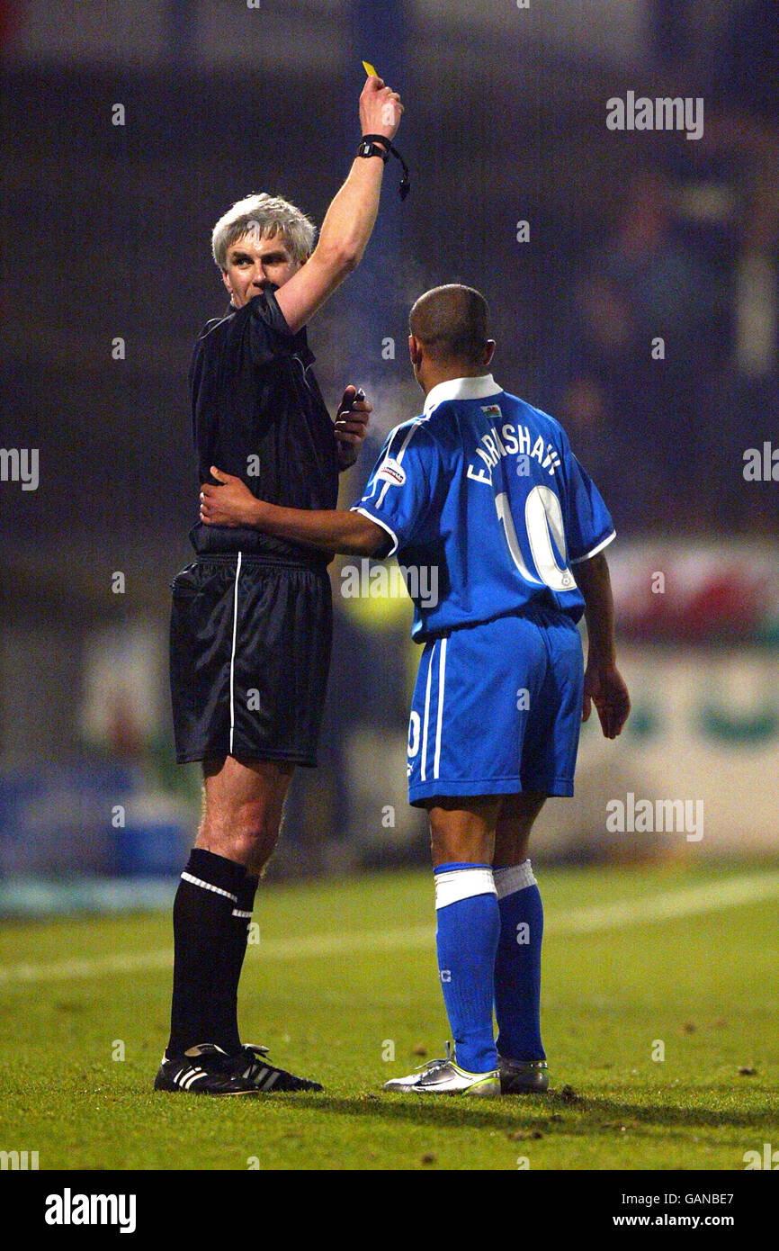 Referee Mark Warren (l) shows a yellow card to Cardiff City's Robert ...