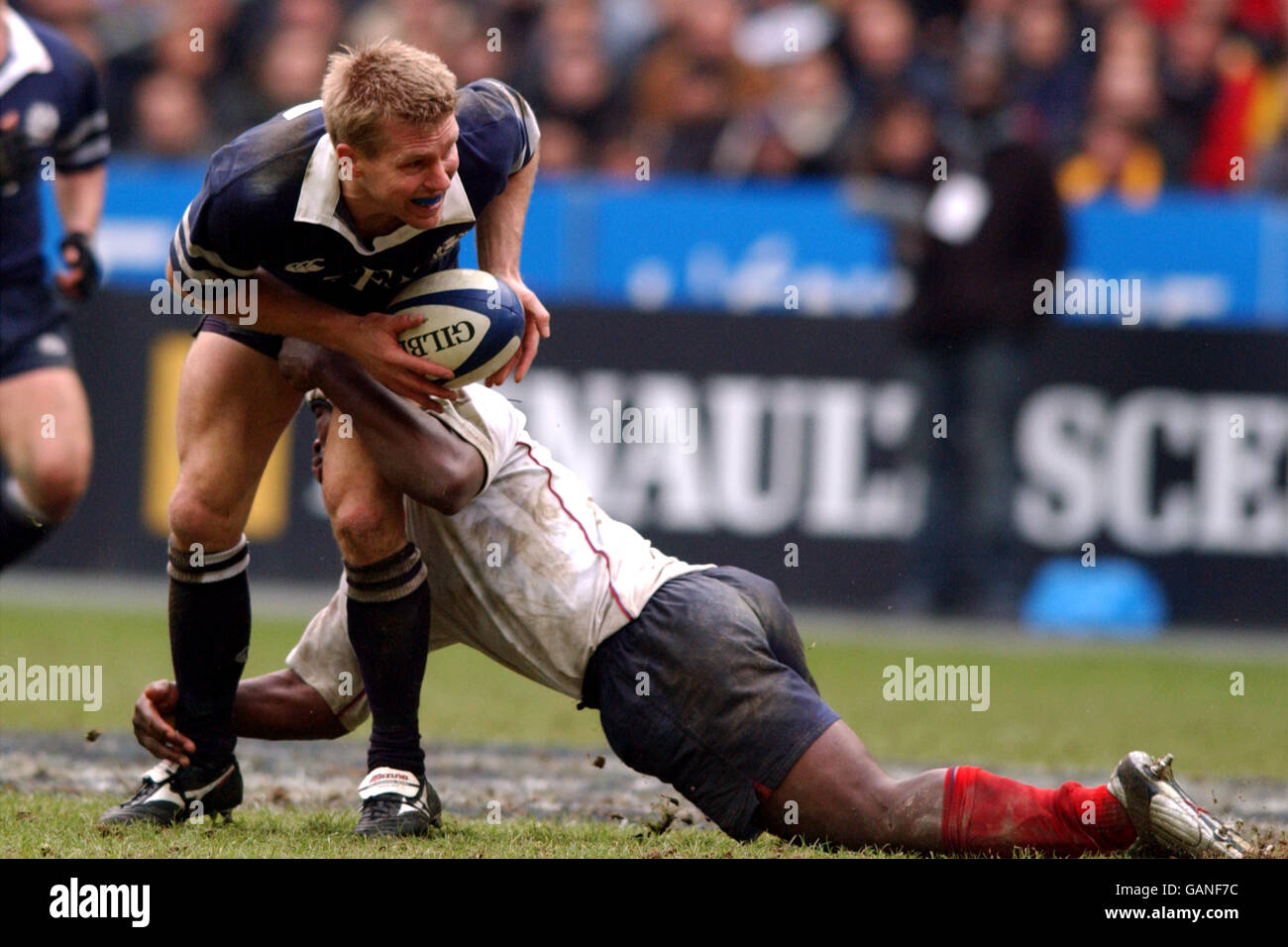 Scotland's Glenn Metcalfe (l) is tackled by France's Serge Betsen Stock ...