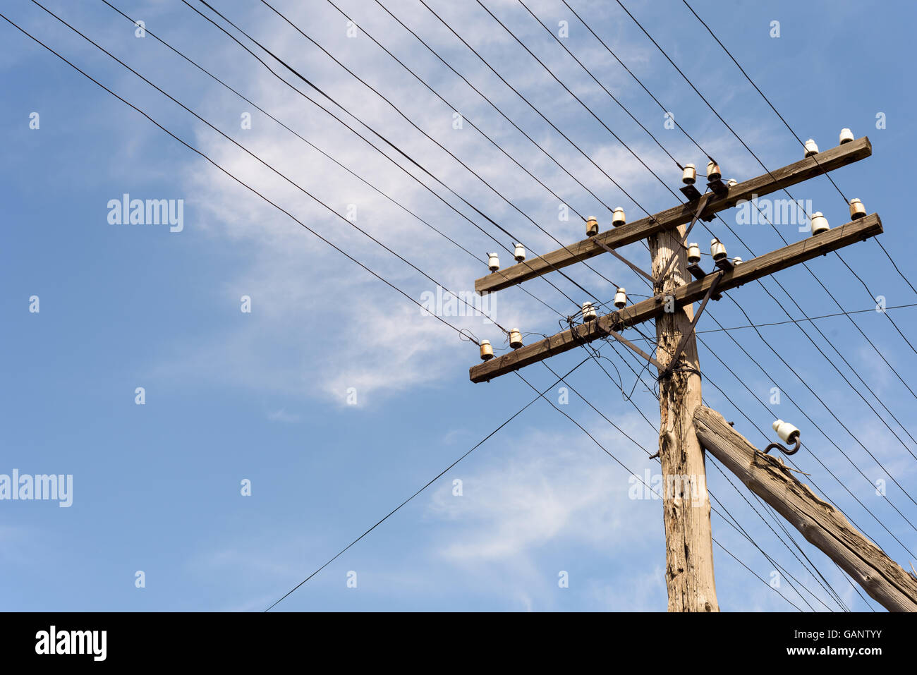 Old wooden electricity pylon with power lines and porcelain insulators ...