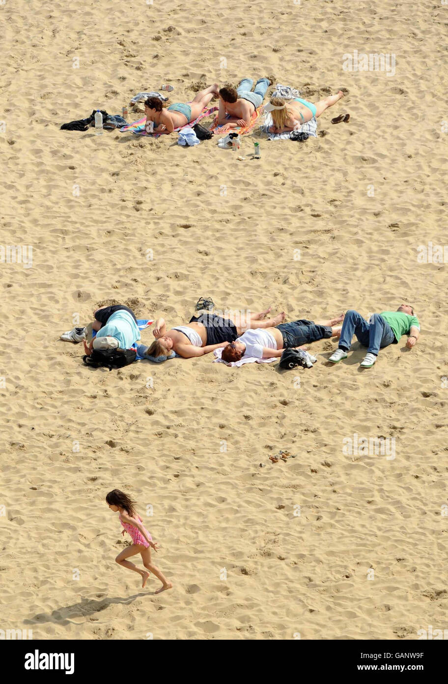 Weather warm at last, for some. People sun-bathing on a beach in ...