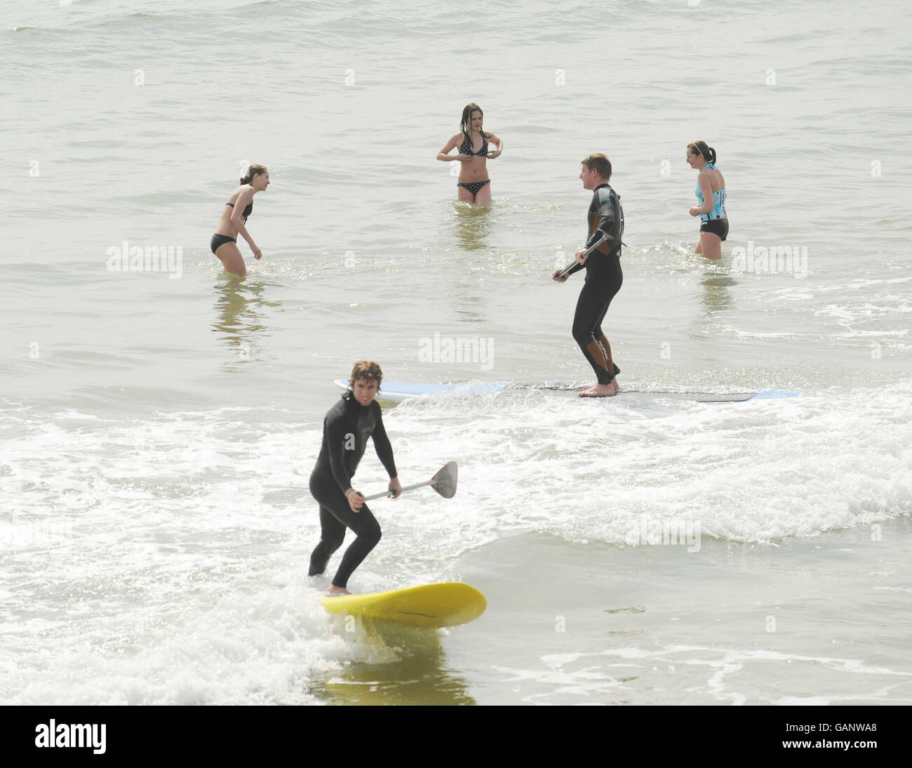 Weather warm at last, for some. People surfing off a beach in ...