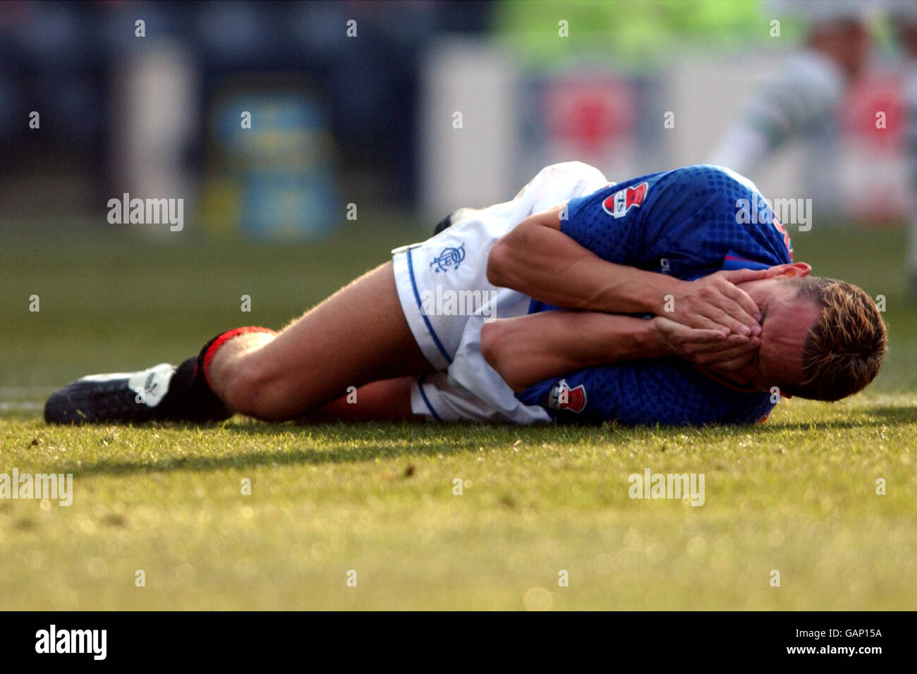 Rangers' Peter Lovenkrands lies on the pitch in agony after a challenge ...