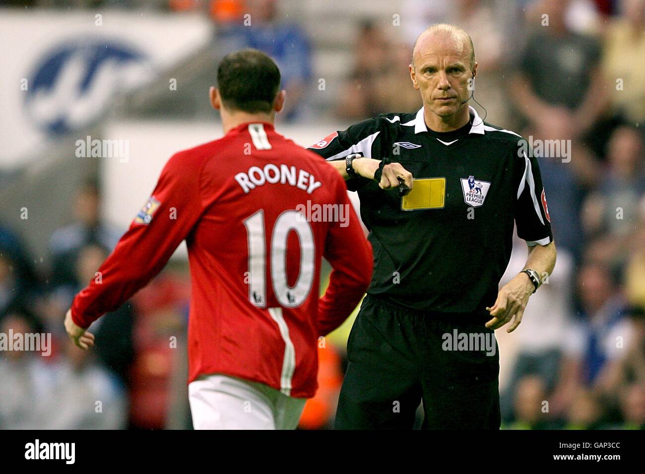 Manchester United's Wayne Rooney is booked by referee Steve Bennett ...