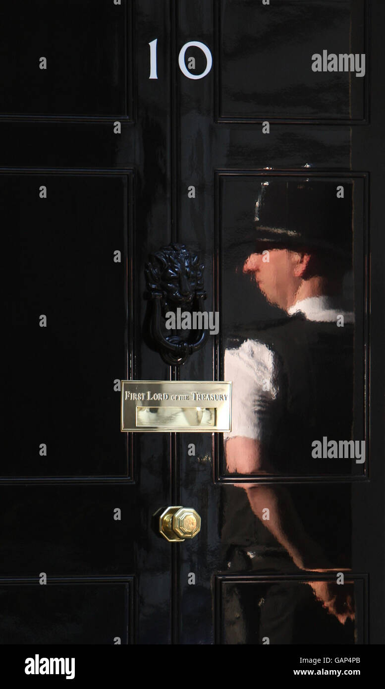 A uniformed Police Officer reflected in the front door of number 10 ...