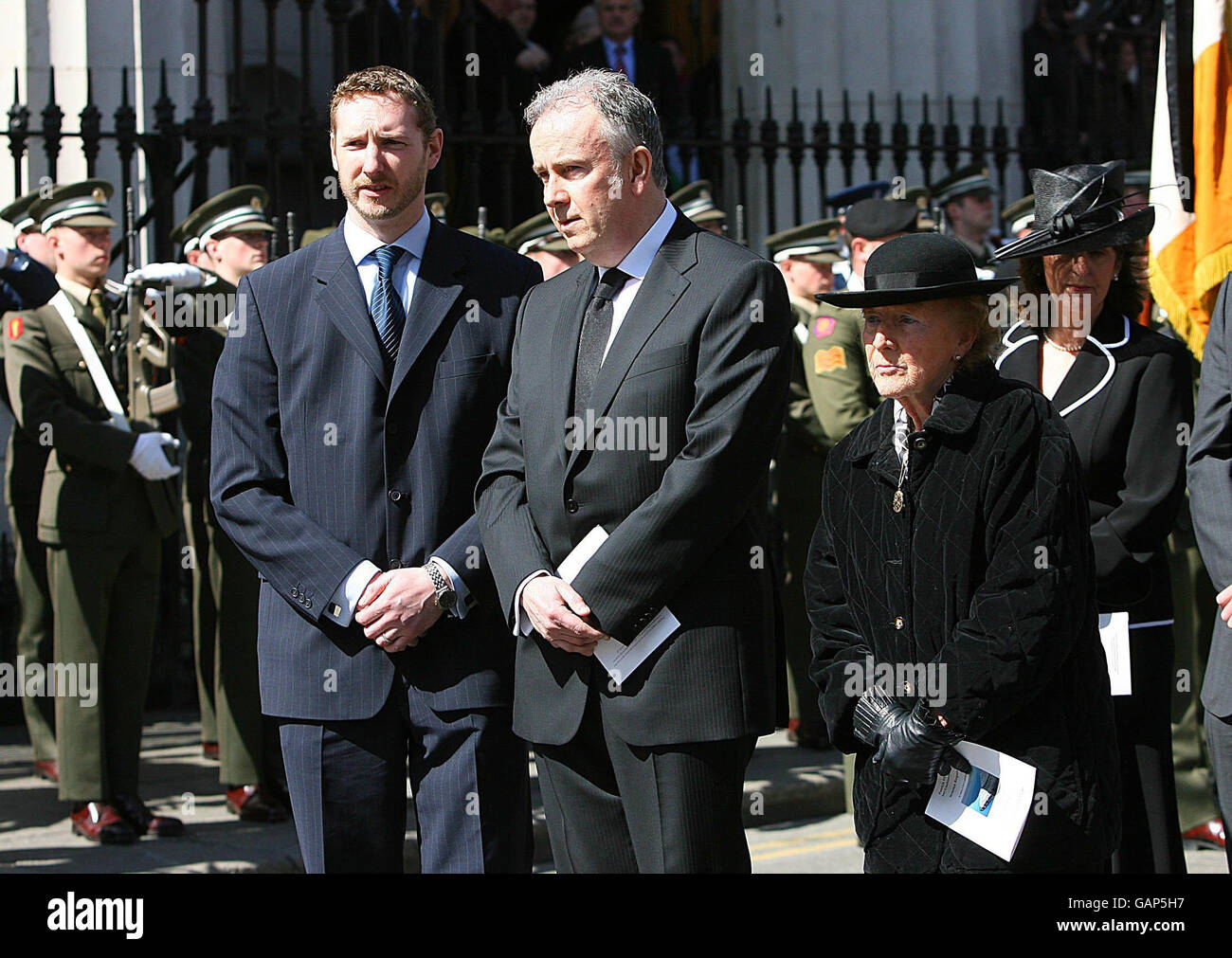 Maeve Hillery (centre) and her son John (right) watch as the coffin of ...