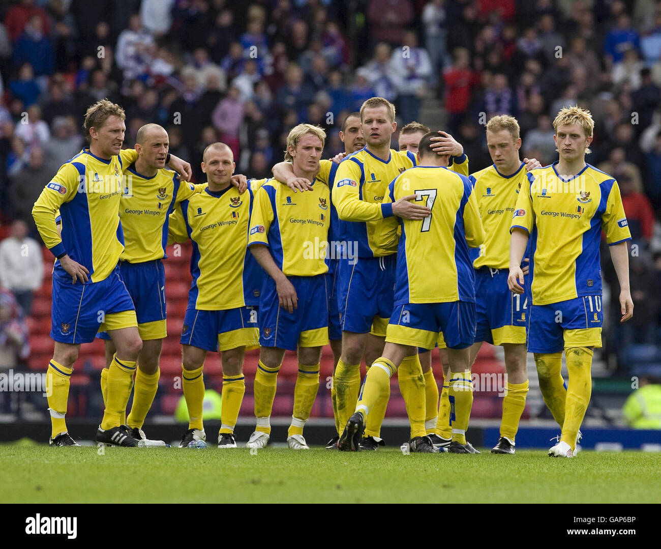 St Johnstone's Steven Milne is consoled by his team-mates after his ...