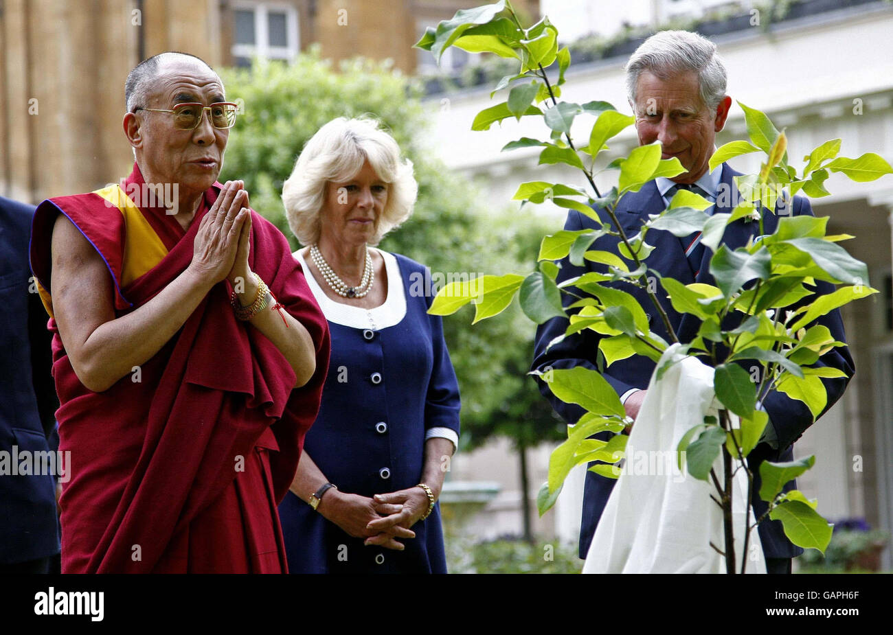 The Dalai Lama prays as the Prince of Wales and Duchess of Cornwall ...