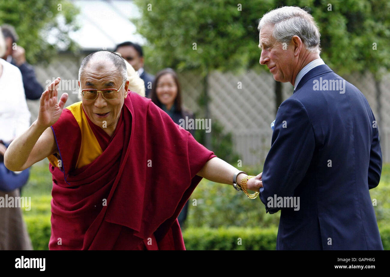 The Dalai Lama waves as the Prince of Wales watches, after planting a ...