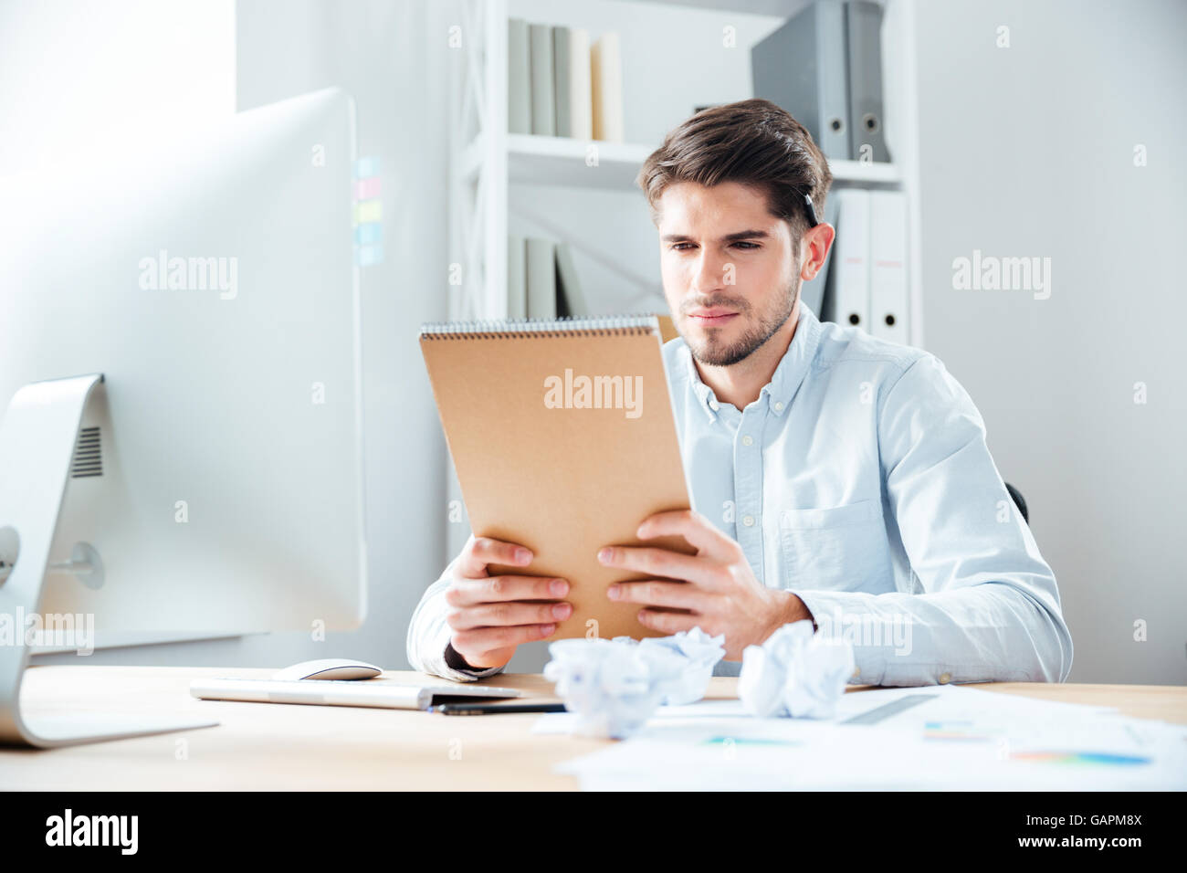 Handsome focused young businessman man sitting and reading notes in ...