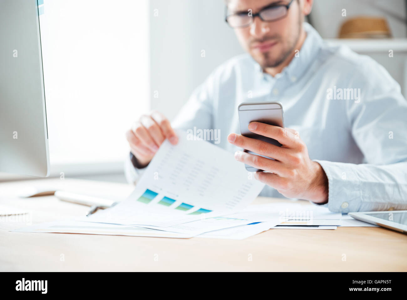 Cropped image of a happy young businessman using mobile phone while ...