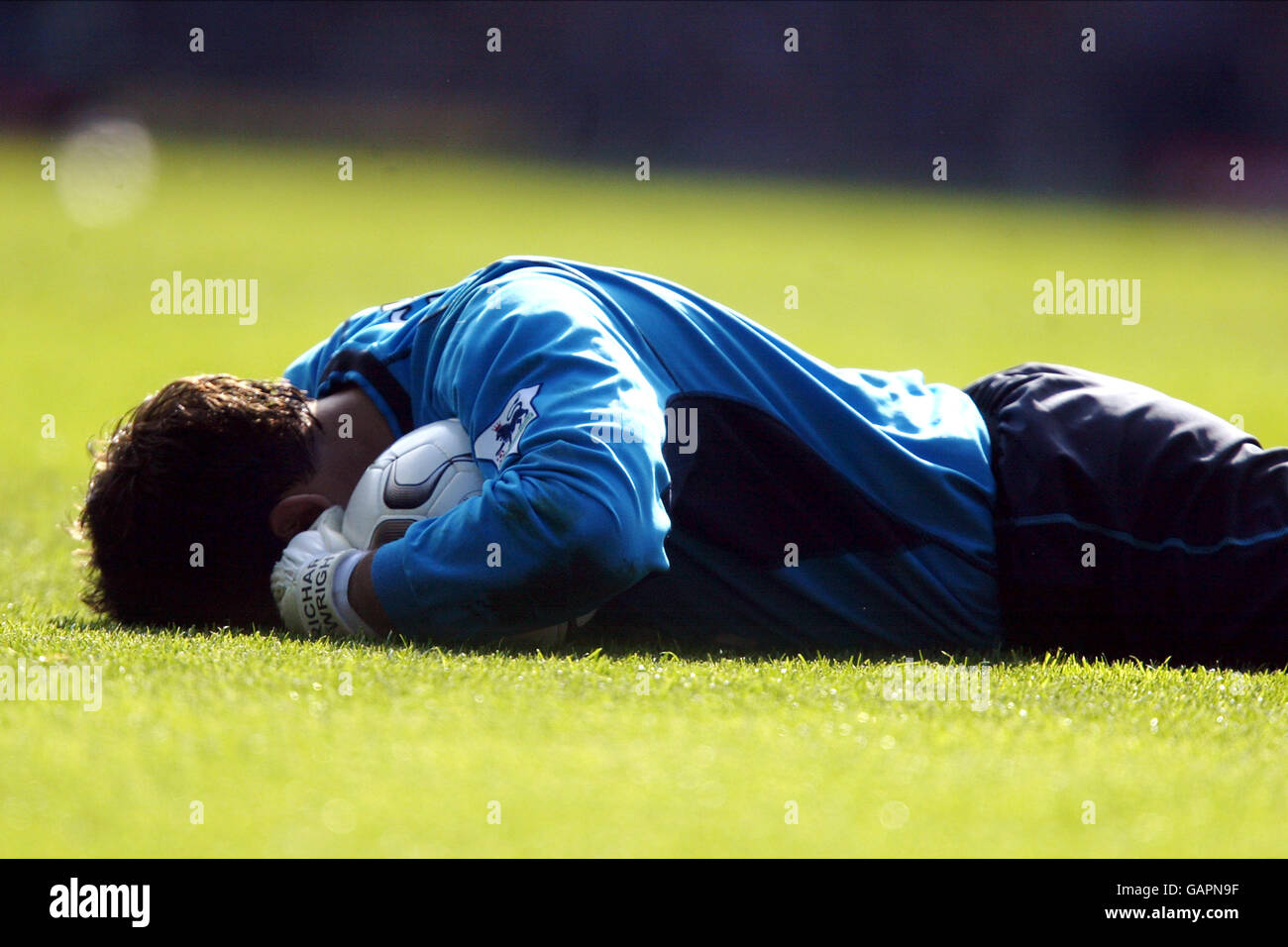 Everton goalkeeper Richard Wright lies on the floor, clutching the ball ...
