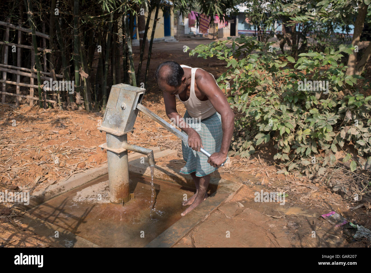 Villager operating a collective water pump in a rural community in West ...