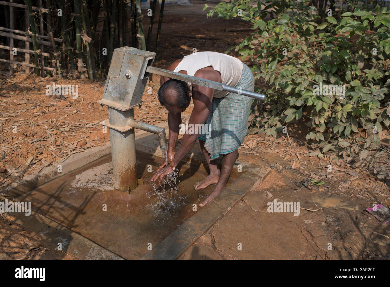 Villager operating a collective water pump in a rural community in West ...