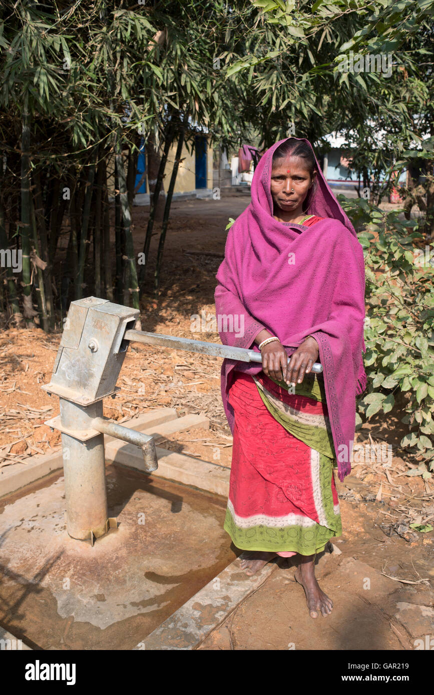 Woman villager by a collective water pump in a rural community in West ...