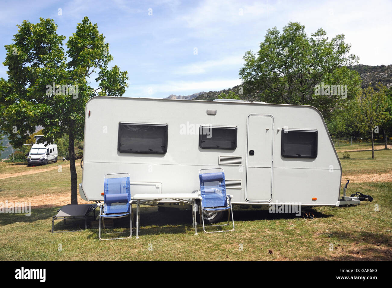 Caravan at a camping with two camping chairs in front Stock Photo - Alamy