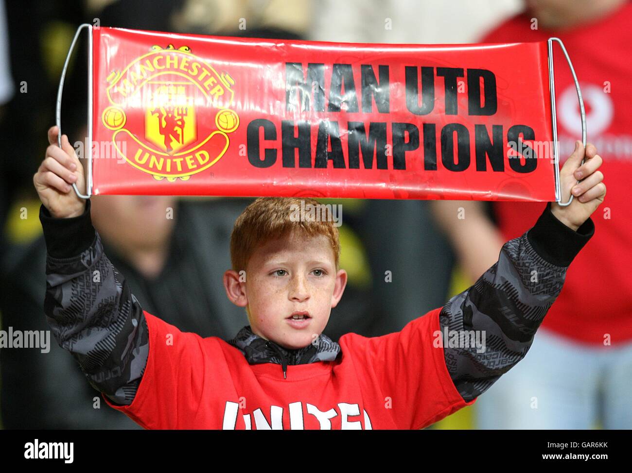 A young Manchester United fan cheers on his side in the stands Stock ...